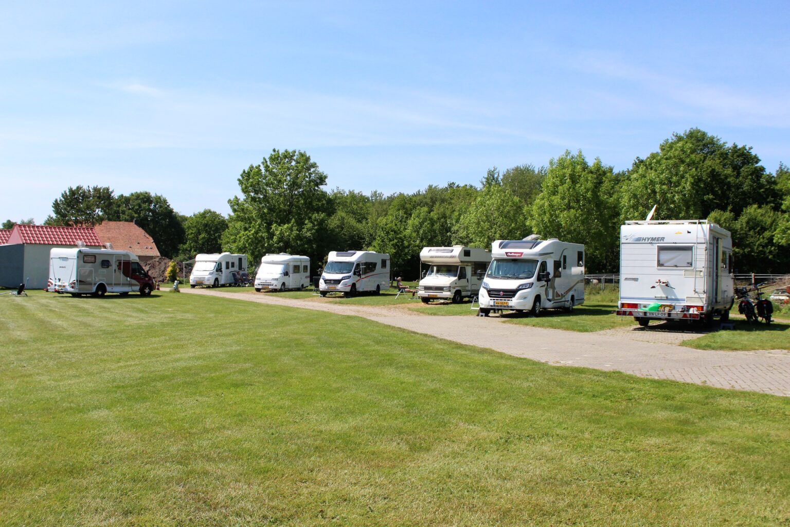 Camperplaatsen op Camping de stal op een rustig veld buiten de camping
